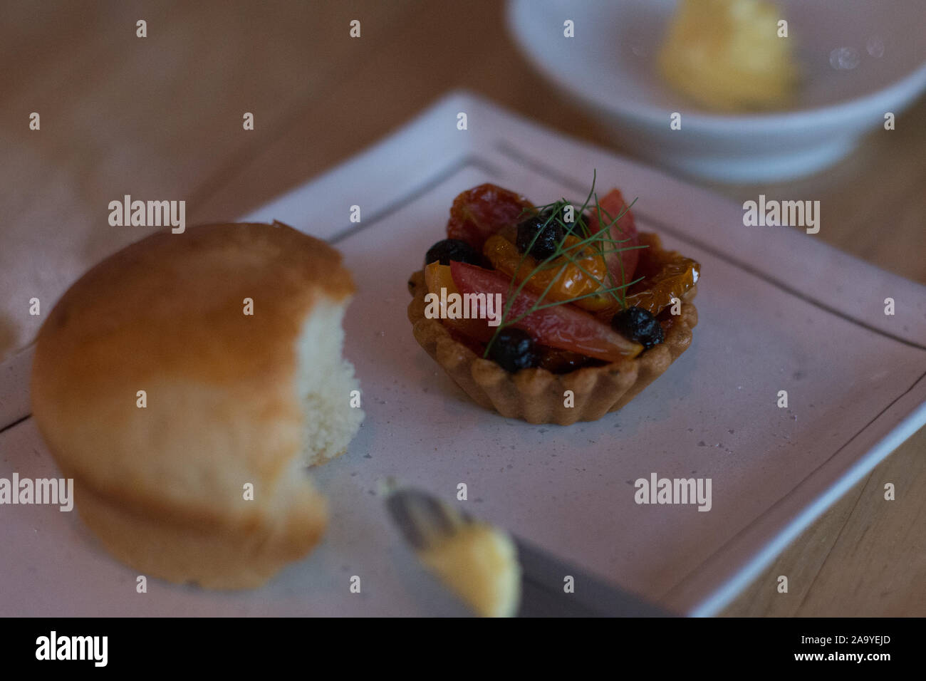 amuse bouche of fruit tart and bread and butter and bottle of water ...