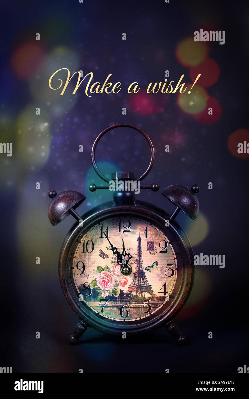 An old vintage clock with sparkles and bokeh lights on a black ...