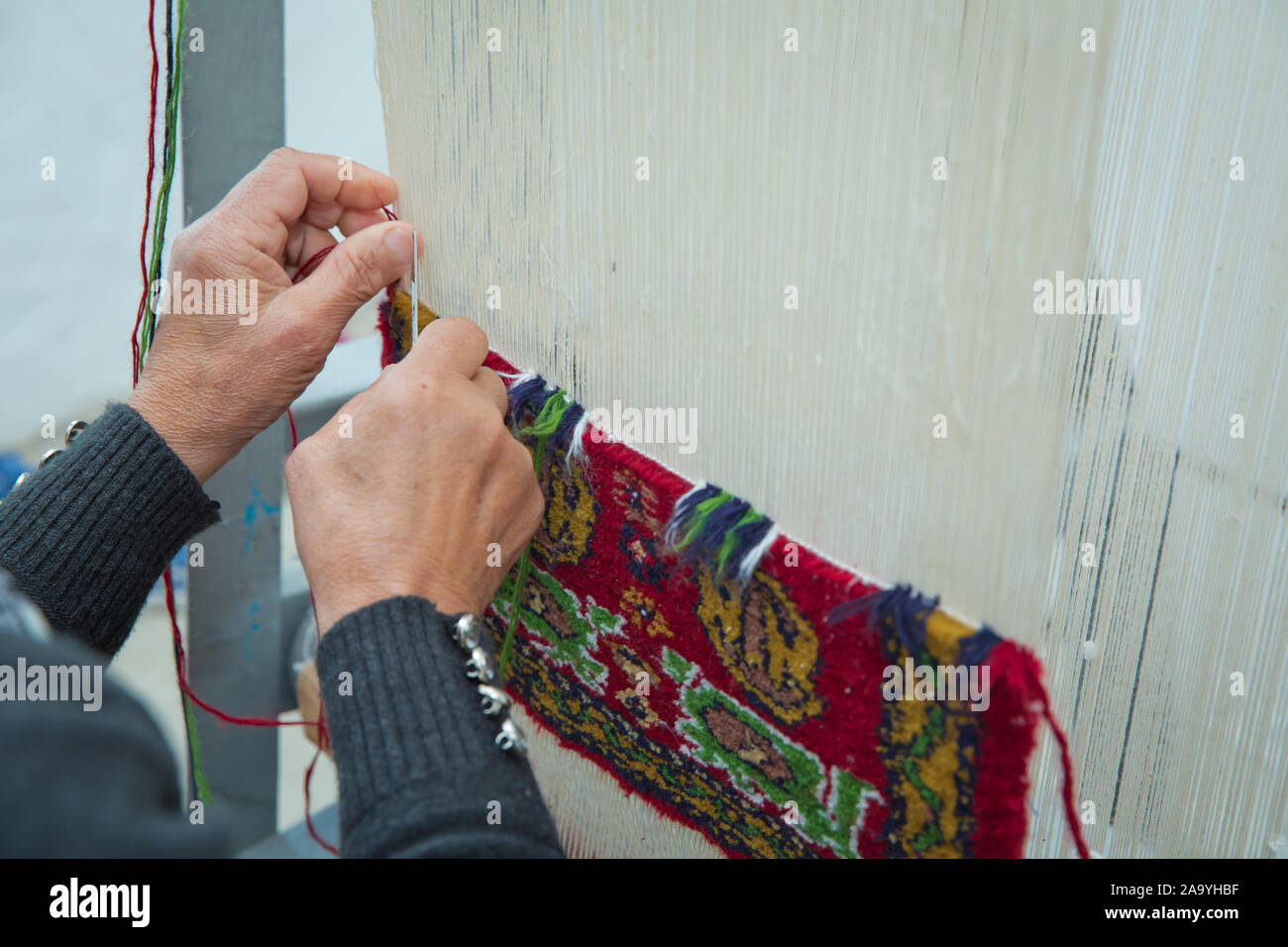 weaving and manufacturing of handmade carpets closeup. women's hands ...