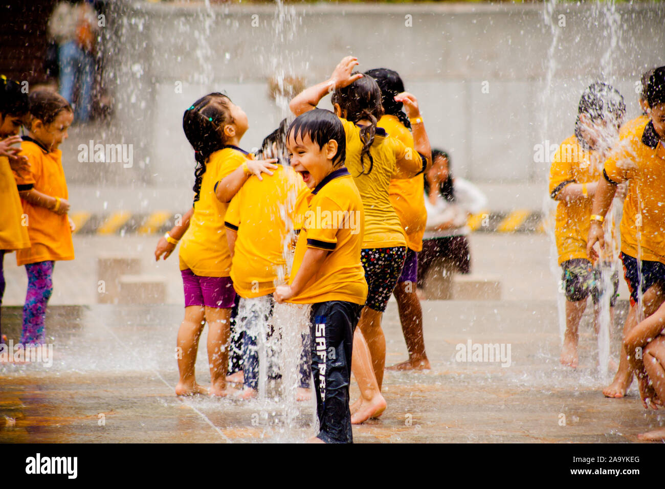 Happy kids playing in the water fountain Stock Photo - Alamy