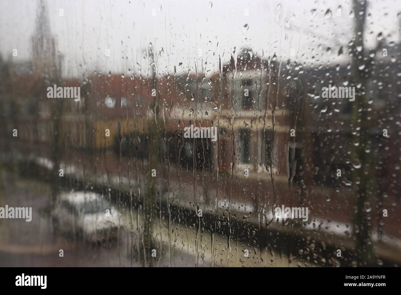 View on a street on a rainy day trough window with waterdrops from the ...