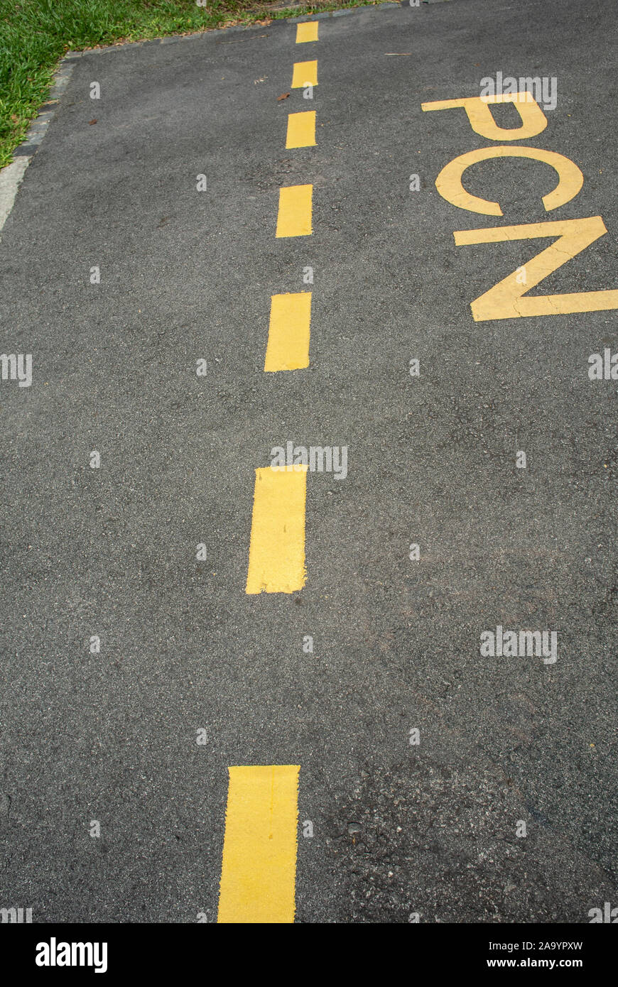 Yellow 'PCN' sign and lines on asphalt road Stock Photo - Alamy