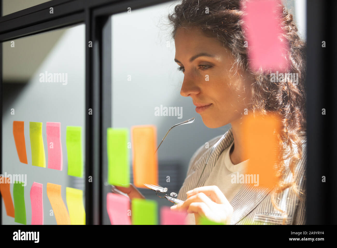 Thoughtful young female boss team leader looking at kanban board Stock ...
