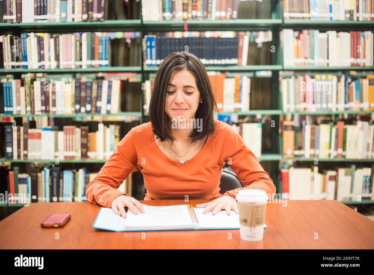 In the library - pretty female student thinking working in a high ...