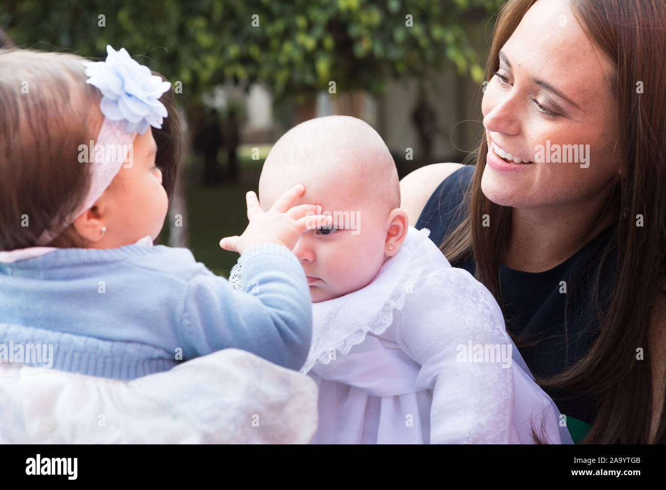 Beautiful mom aunt with adorable babies Stock Photo - Alamy