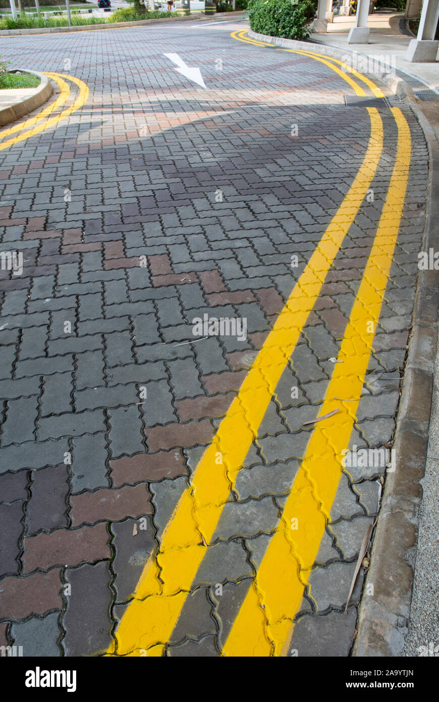 double yellow lines painted on interlocking concrete pavement Stock ...