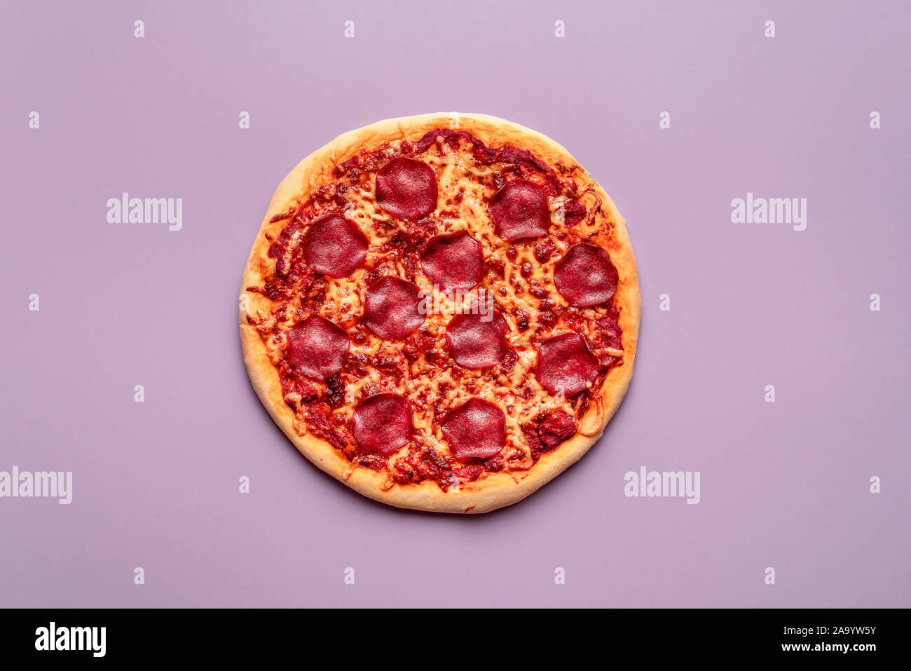 Hot pepperoni pizza on a purple background. Above view of whole Italian ...