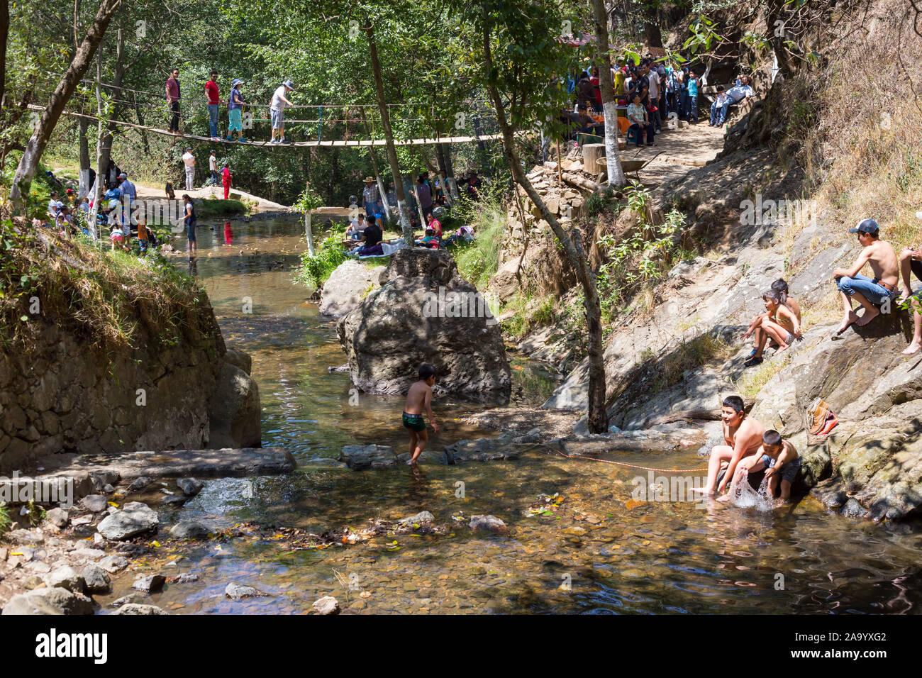 Latin Hispanic mexican kids and people playing and swimming in a river ...