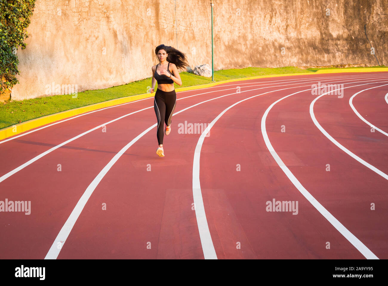 Young woman runner running race on athletics track Stock Photo - Alamy