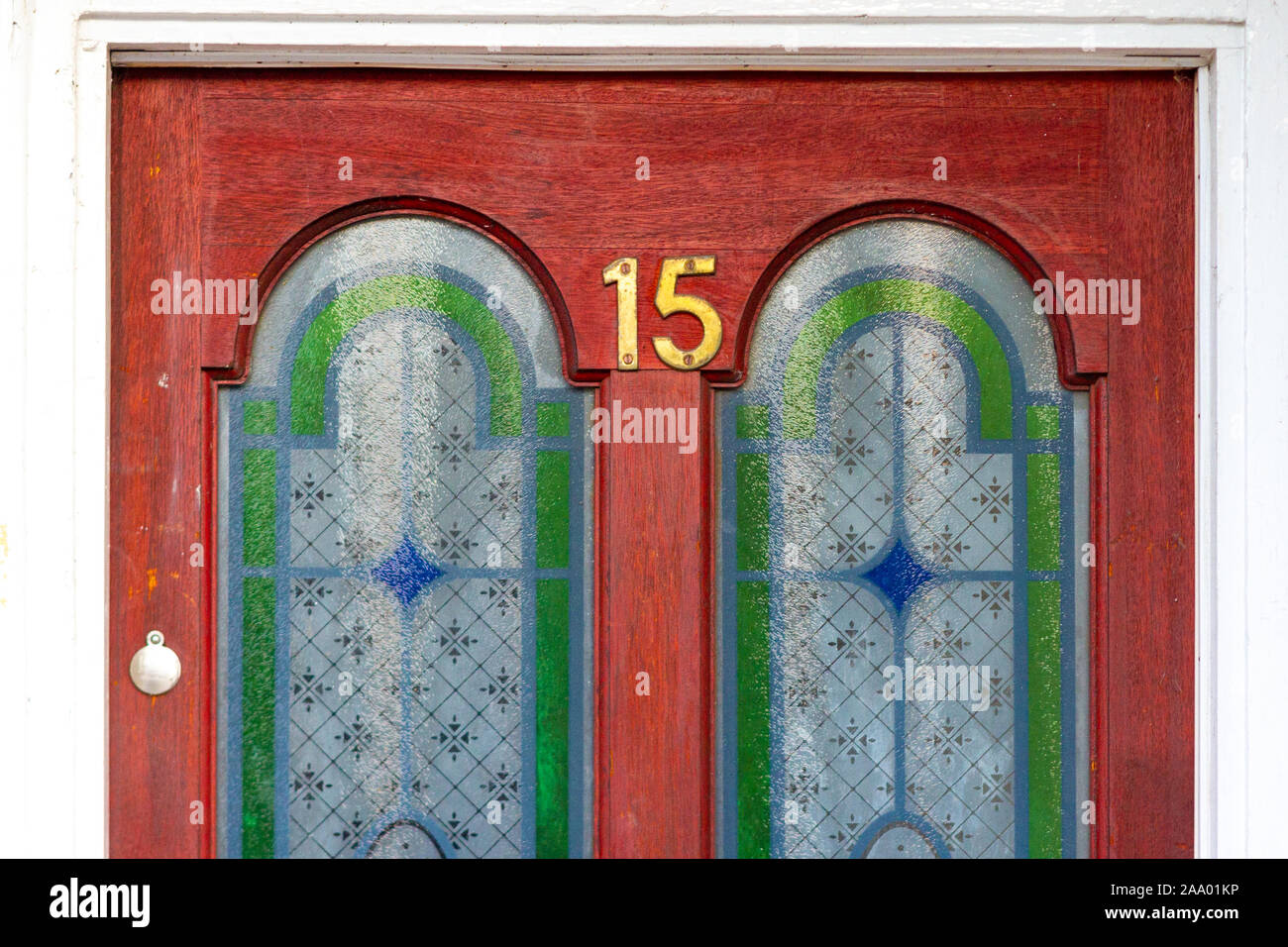 Elegant and stately house number 15 on a brown wooden front door with ...