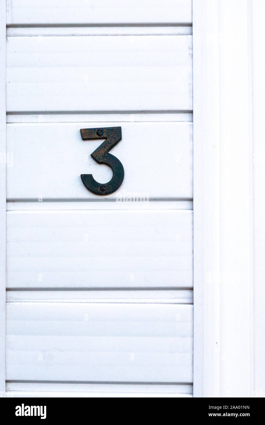 House number 3 on a white wooden wall made out of boards Stock Photo ...
