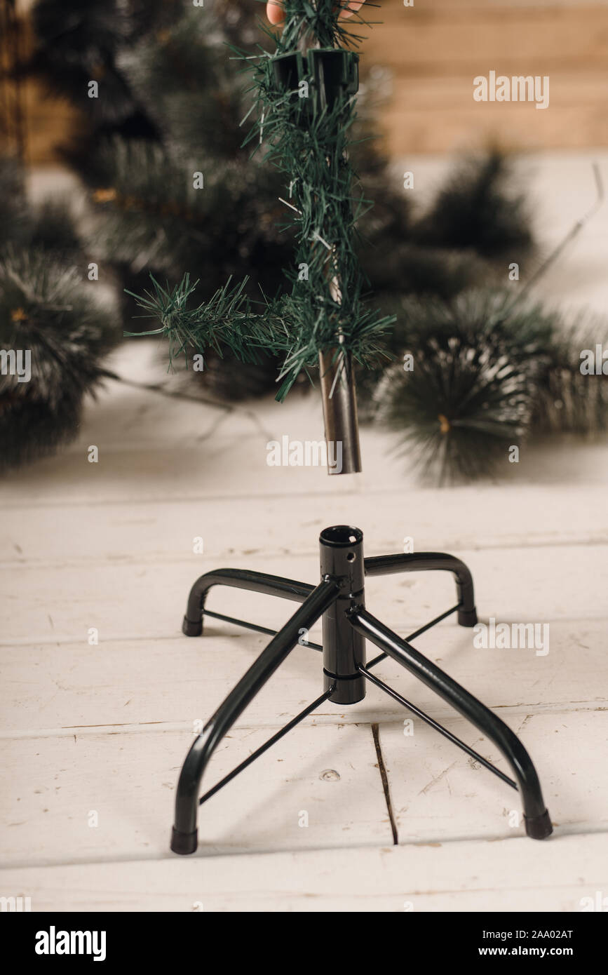 Man collects artificial Christmas tree at home. The stage of Assembly ...