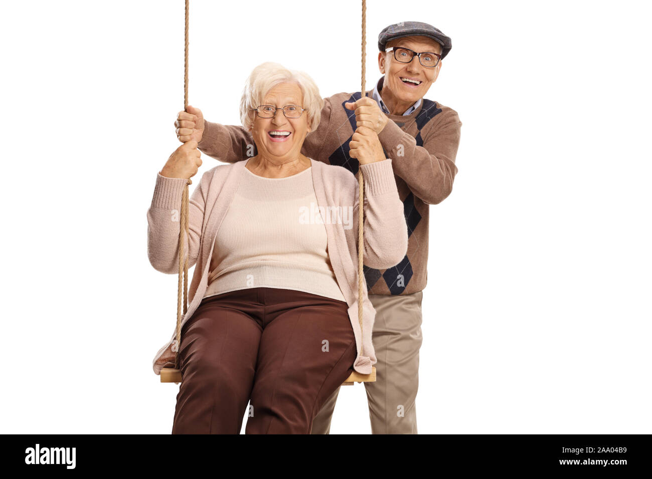 Elderly man pushing an elderly woman on a swing isolated on white ...