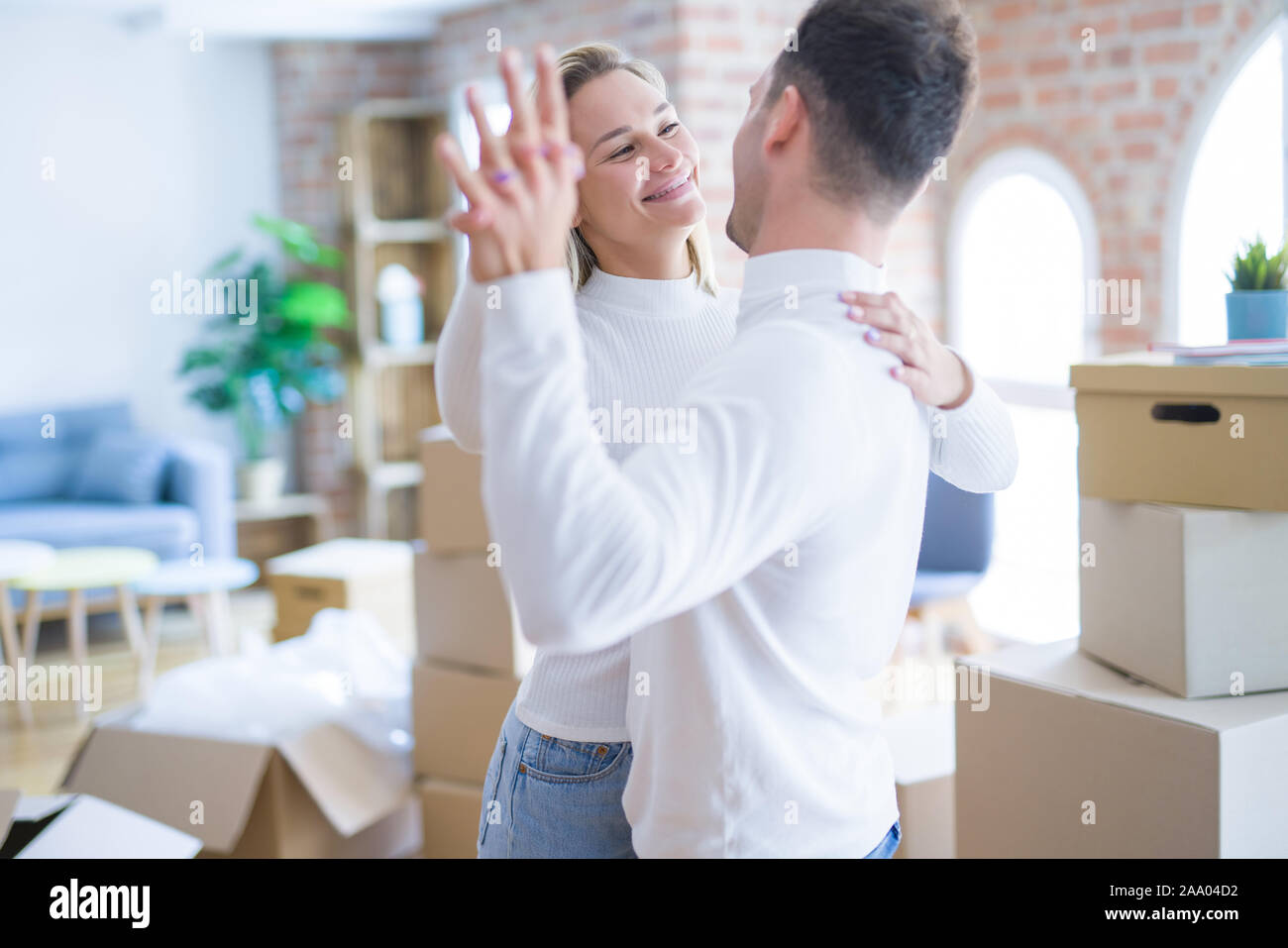 Young beautiful couple dancing at new home around cardboard boxes Stock ...