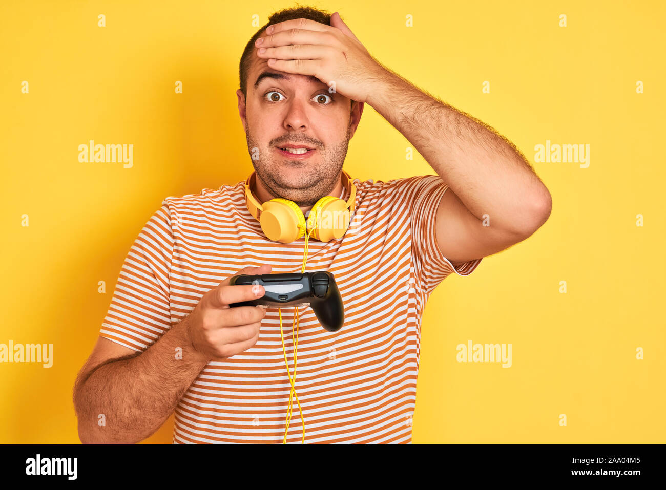 Young gamer man playing video game using headphones over isolated ...