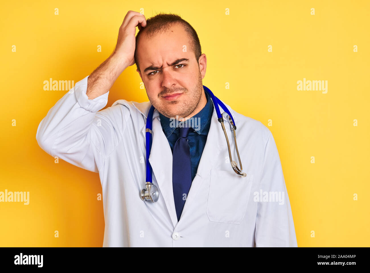 Young doctor man wearing coat and stethoscope standing over isolated ...