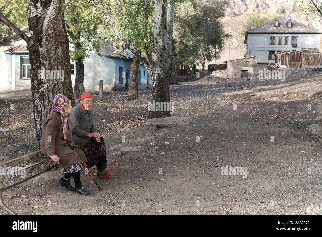 Old women sit on bench in the former Soviet uranium mining town of Min ...