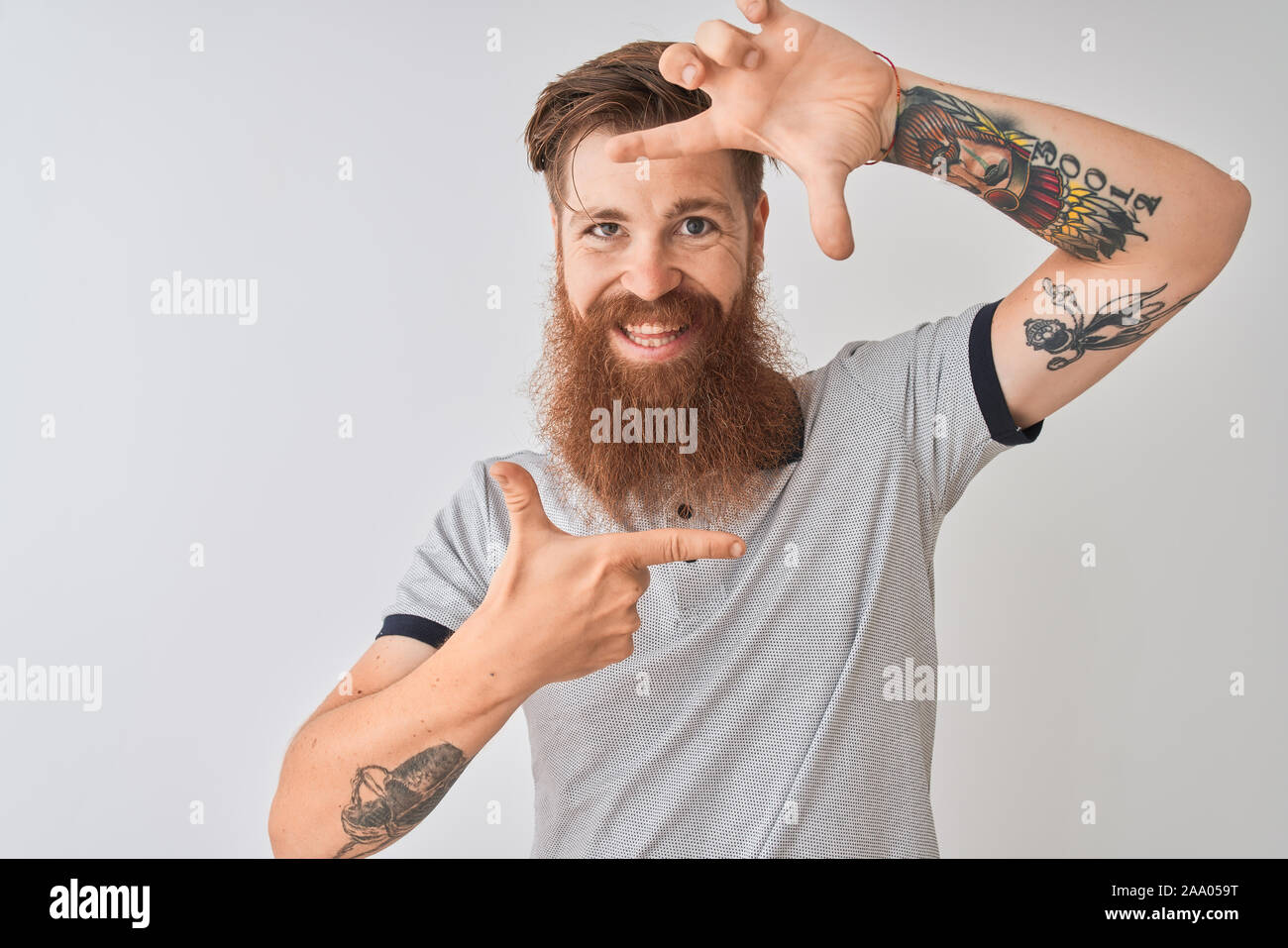 Young redhead irish man wearing grey polo standing over isolated white ...