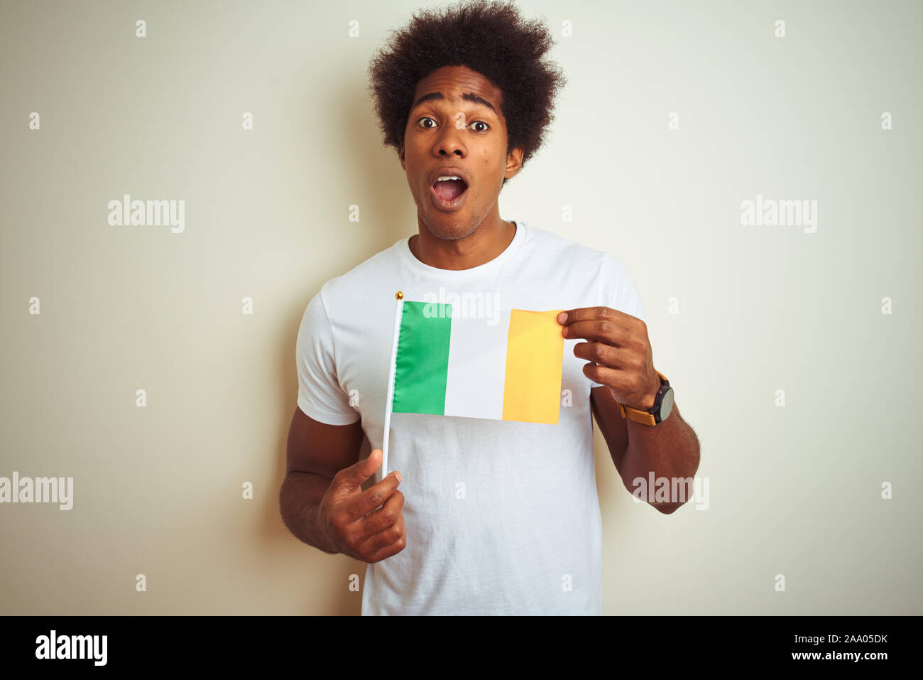 Young african american man holding Ireland Irish flag standing over ...
