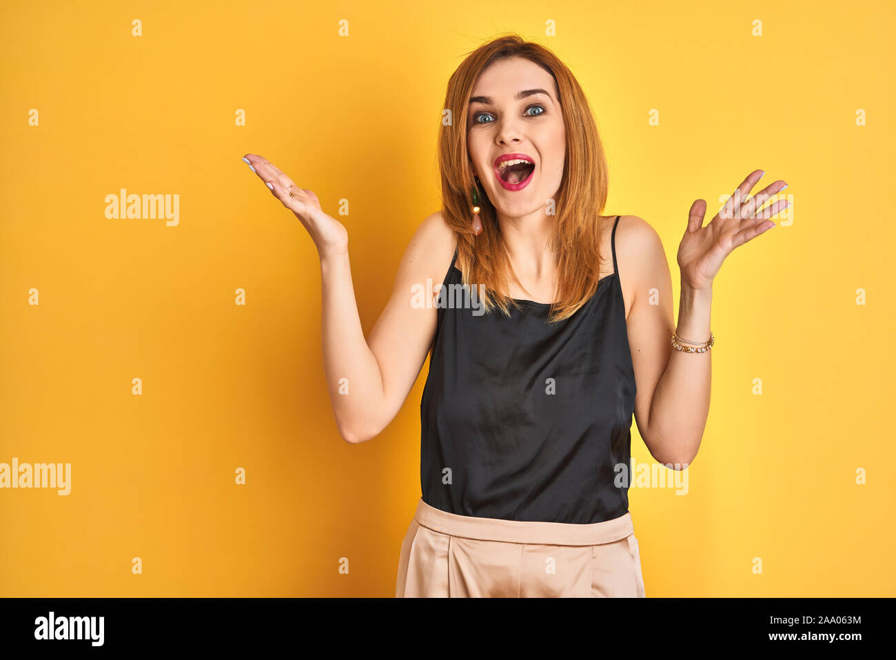 Redhead caucasian business woman standing over yellow isolated ...