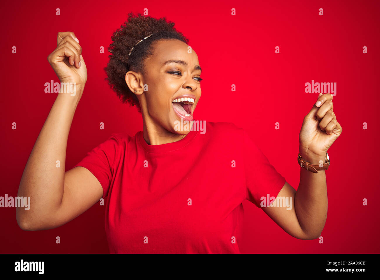 Young beautiful african american woman with afro hair over isolated red ...
