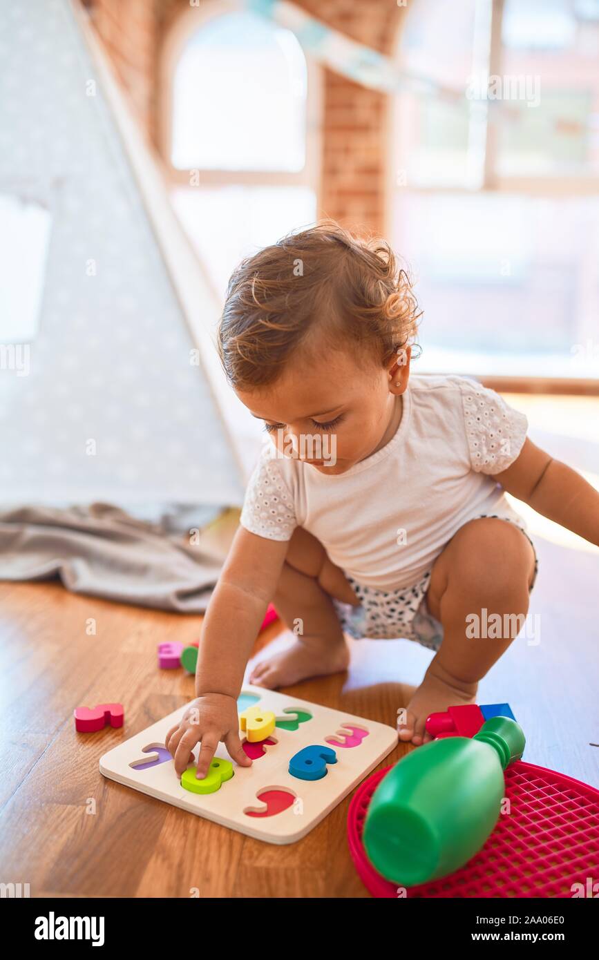 Adorable toddler learning numbers using maths puzzle around lots of ...