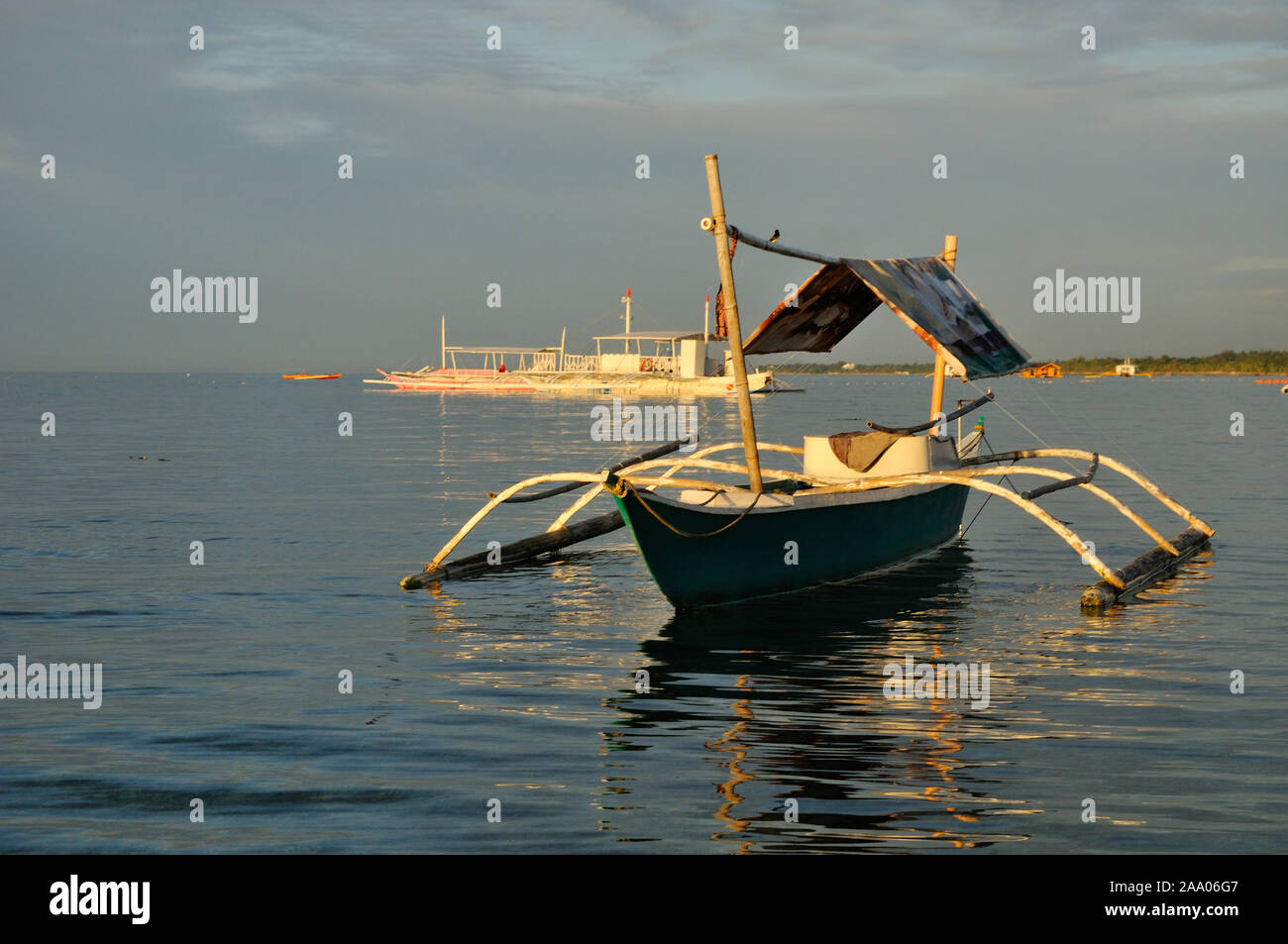 Small fishing outrigger boat is anchored near the shore, Panglao ...