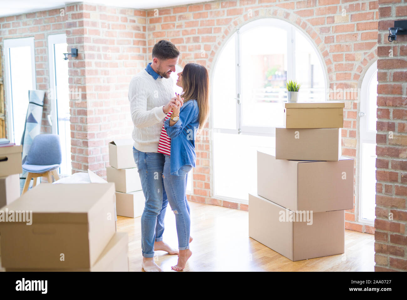 Young beautiful couple dancing at new home around cardboard boxes Stock ...