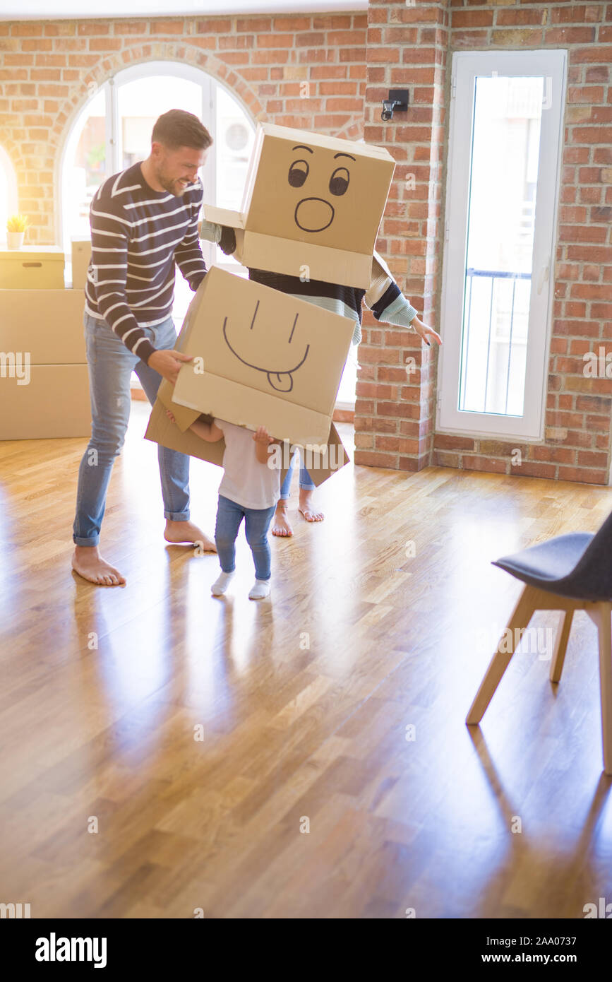 Beautiful famiily with kid playing with cardboard fanny boxes at new ...