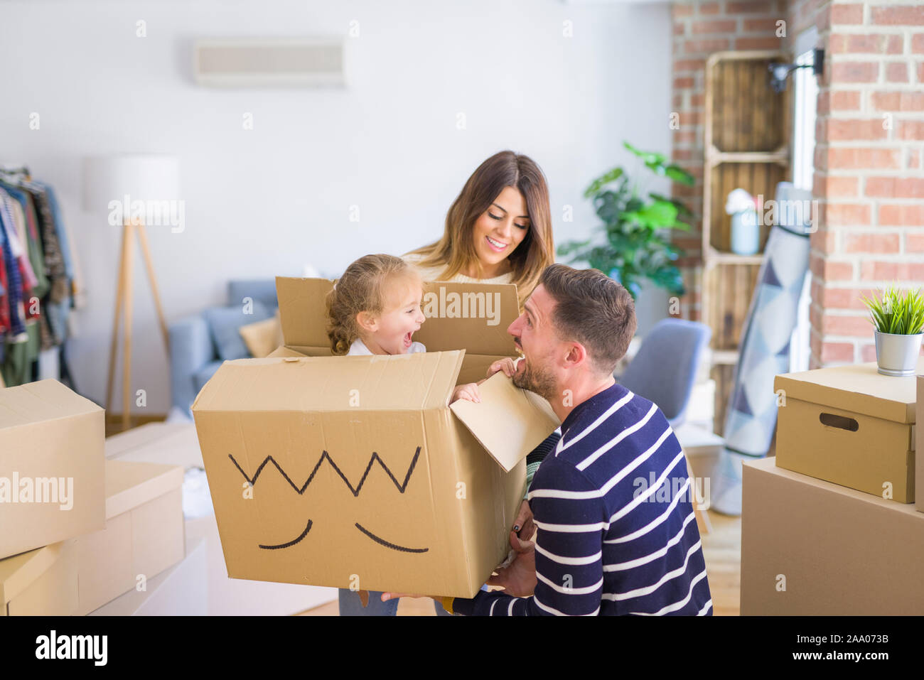 Beautiful famiily, kid playing with his parents riding cardboard fanny ...