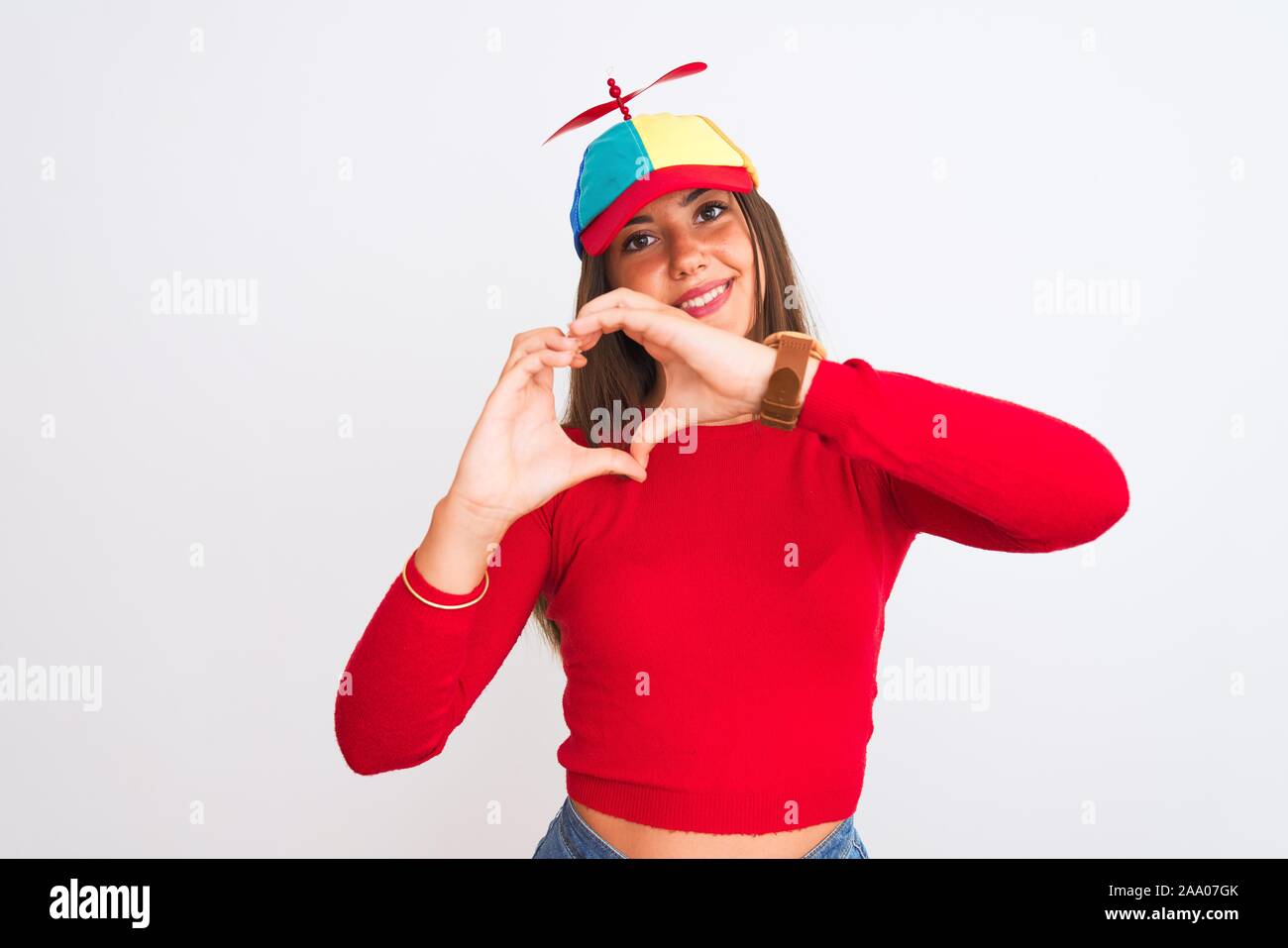 Young beautiful girl wearing fanny cap with propeller standing over ...