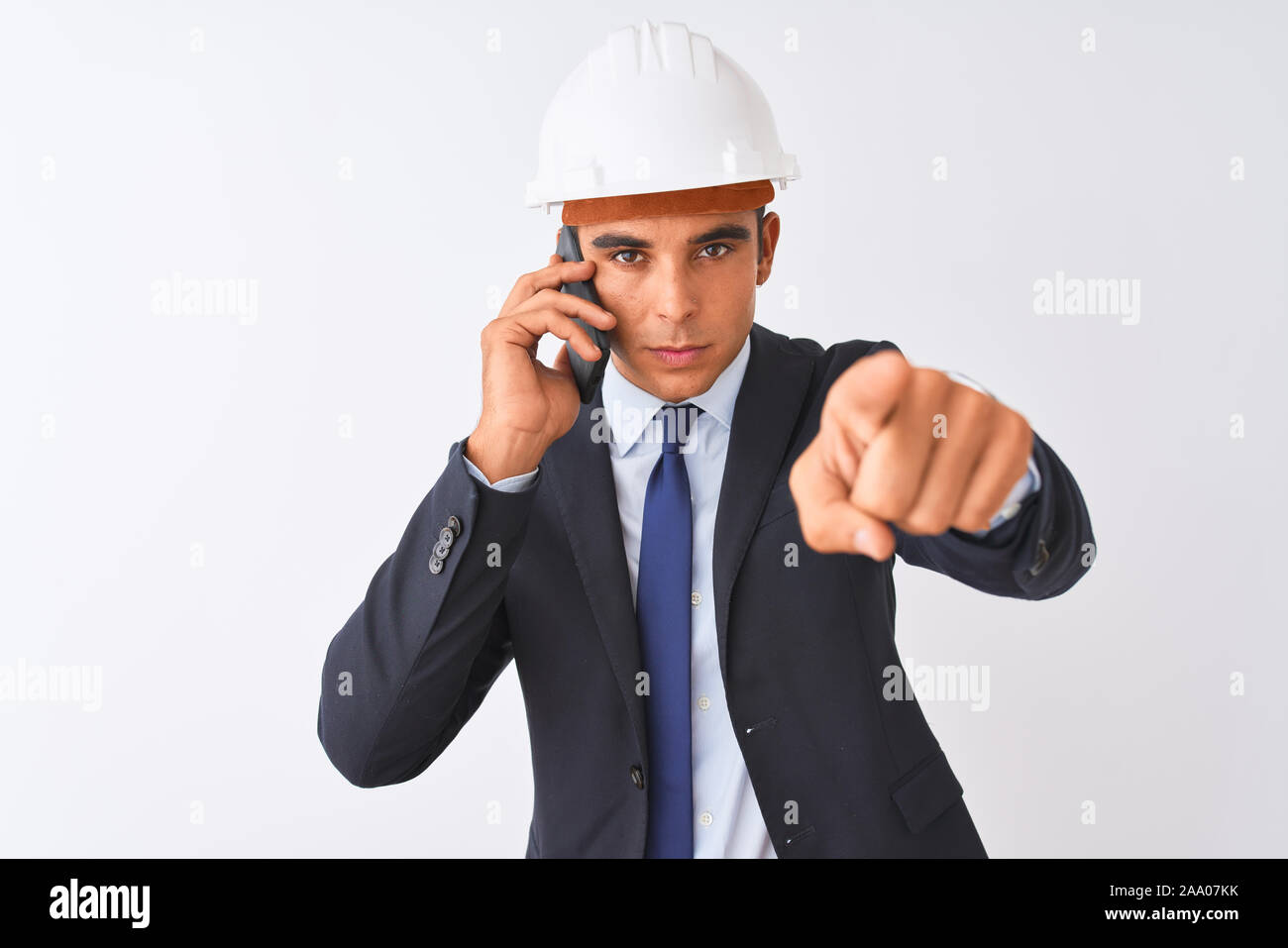 Young architect man wearing helmet talking on smartphone over isolated ...