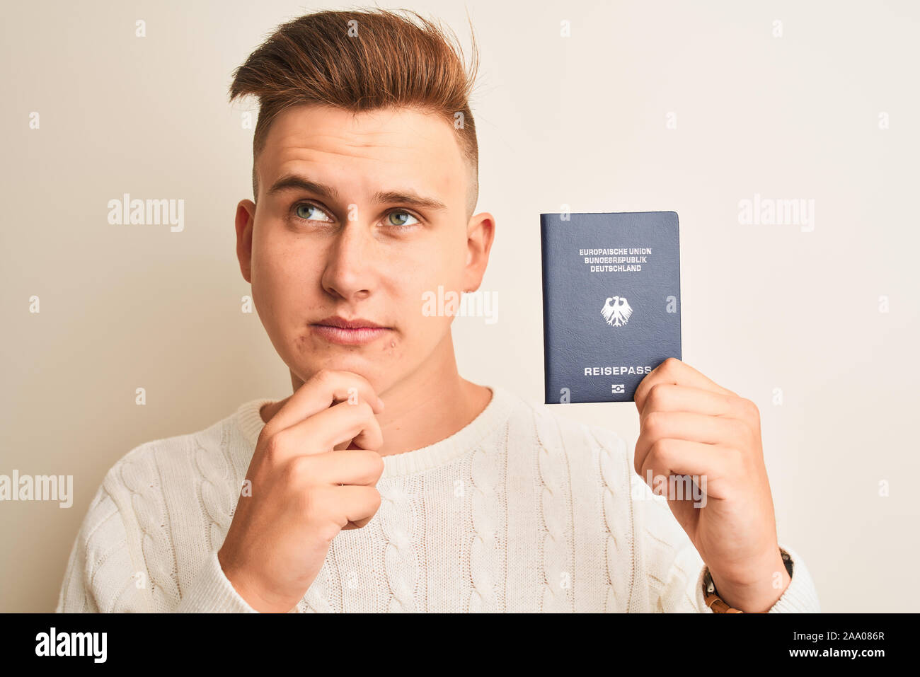 Young handsome man holding Germany German passport over isolated white ...