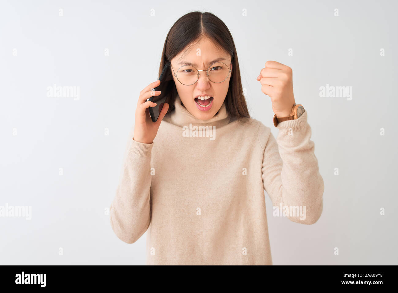 Young chinese woman talking on the smartphone over isolated white ...