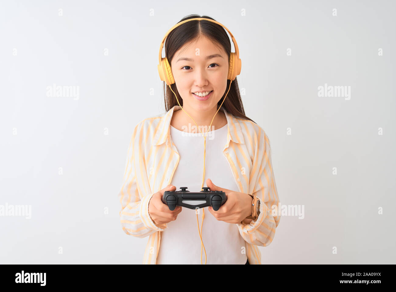 Chinese gamer woman playing video game using headphones over isolated ...