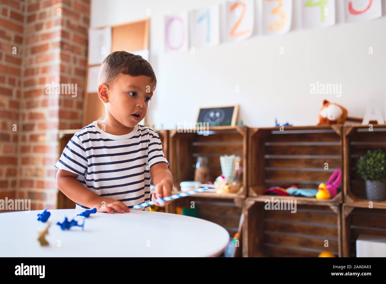 Beautiful toddler boy playing with figurine army soldiers at ...