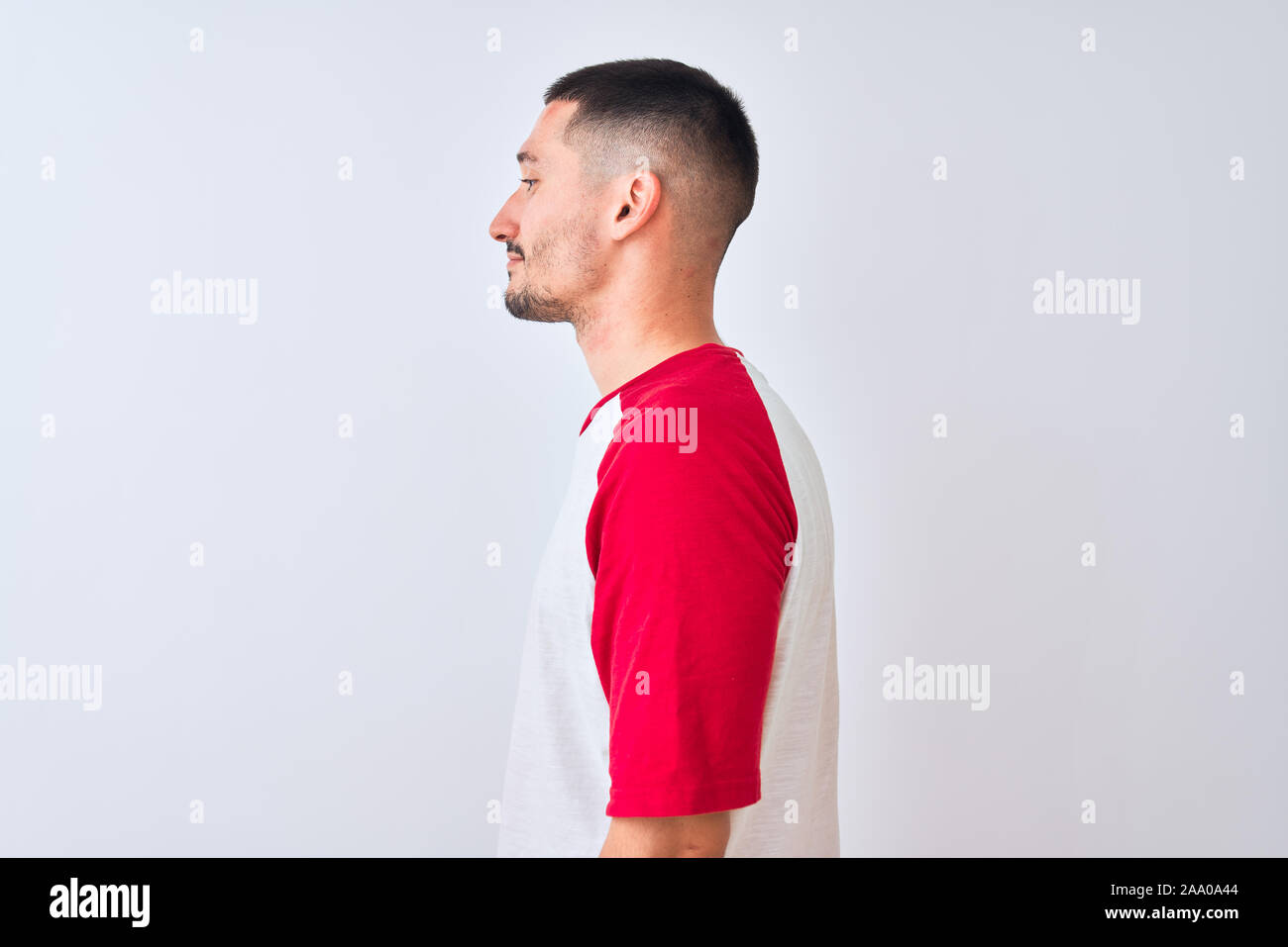Young handsome man standing over isolated background looking to side ...