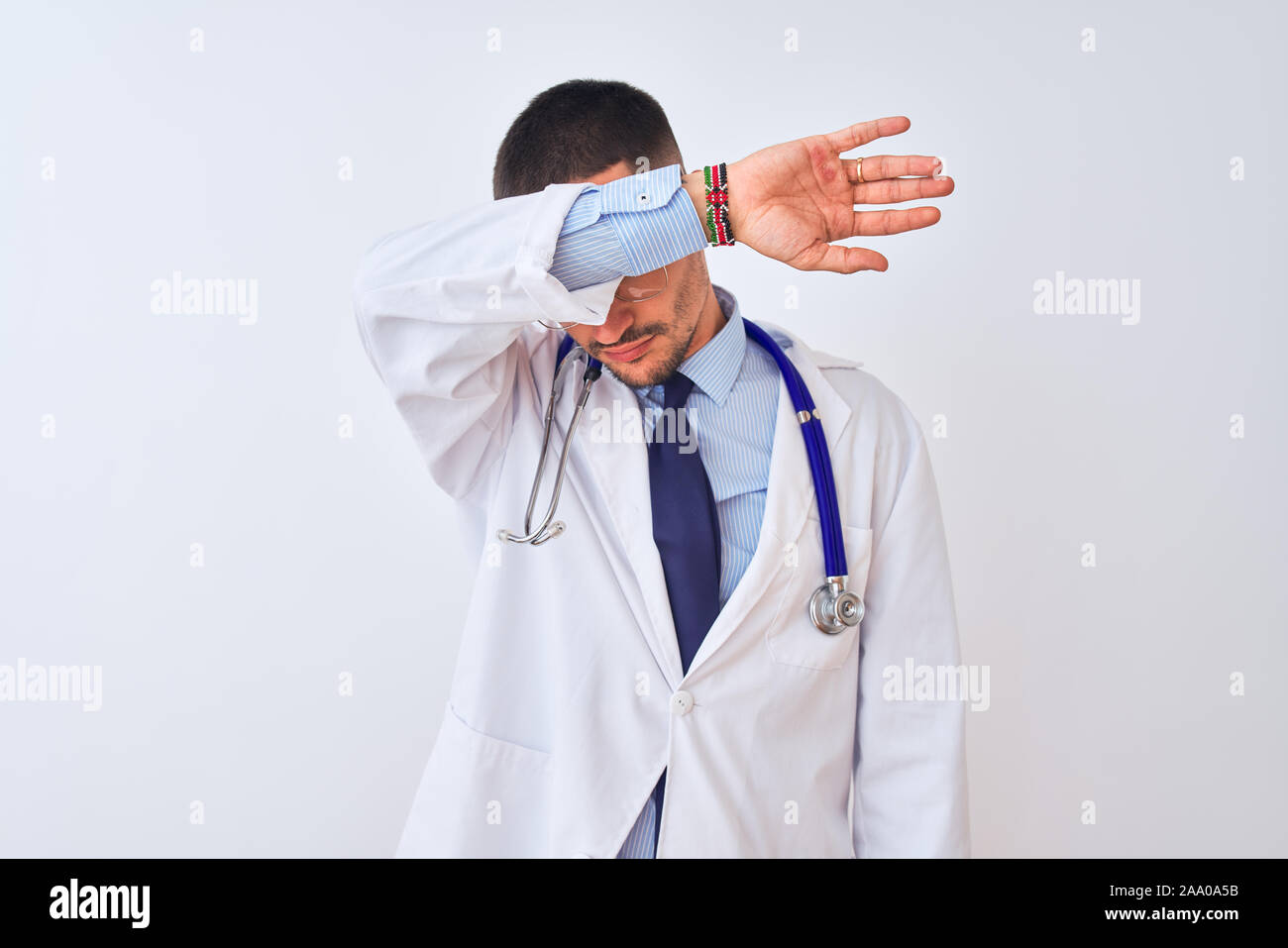 Young doctor man wearing stethoscope over isolated background covering ...