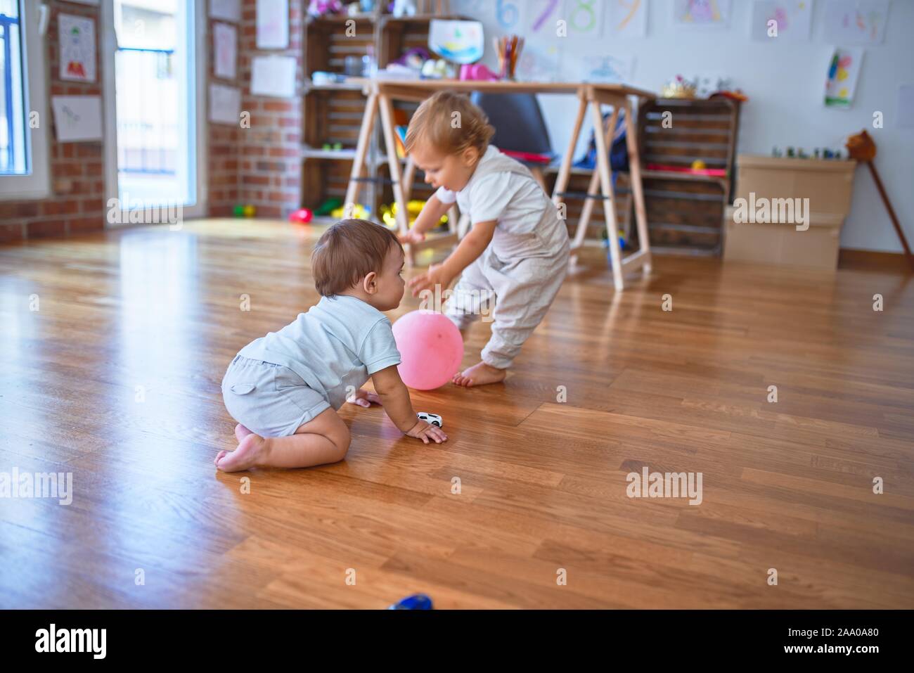 Beautiful toddlers playing around lots of toys at kindergarten Stock ...