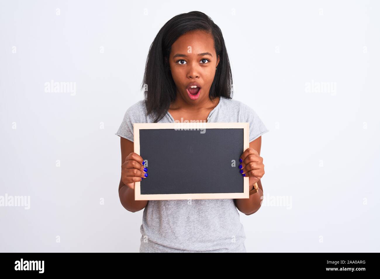 Young african american woman holding blank school blackboard over ...