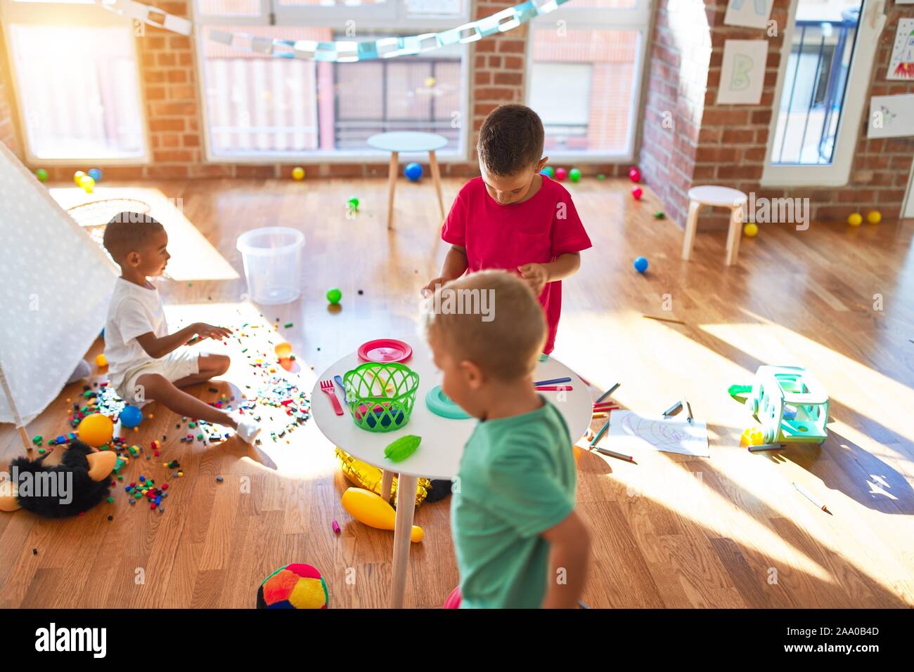 Adorable toddlers playing around lots of toys at kindergarten Stock ...