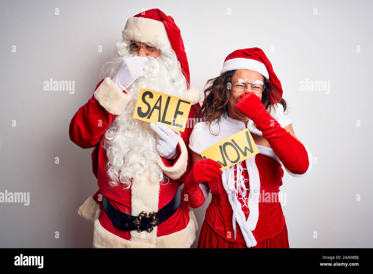 Couple wearing Santa costume holding wow and sale banner over isolated ...