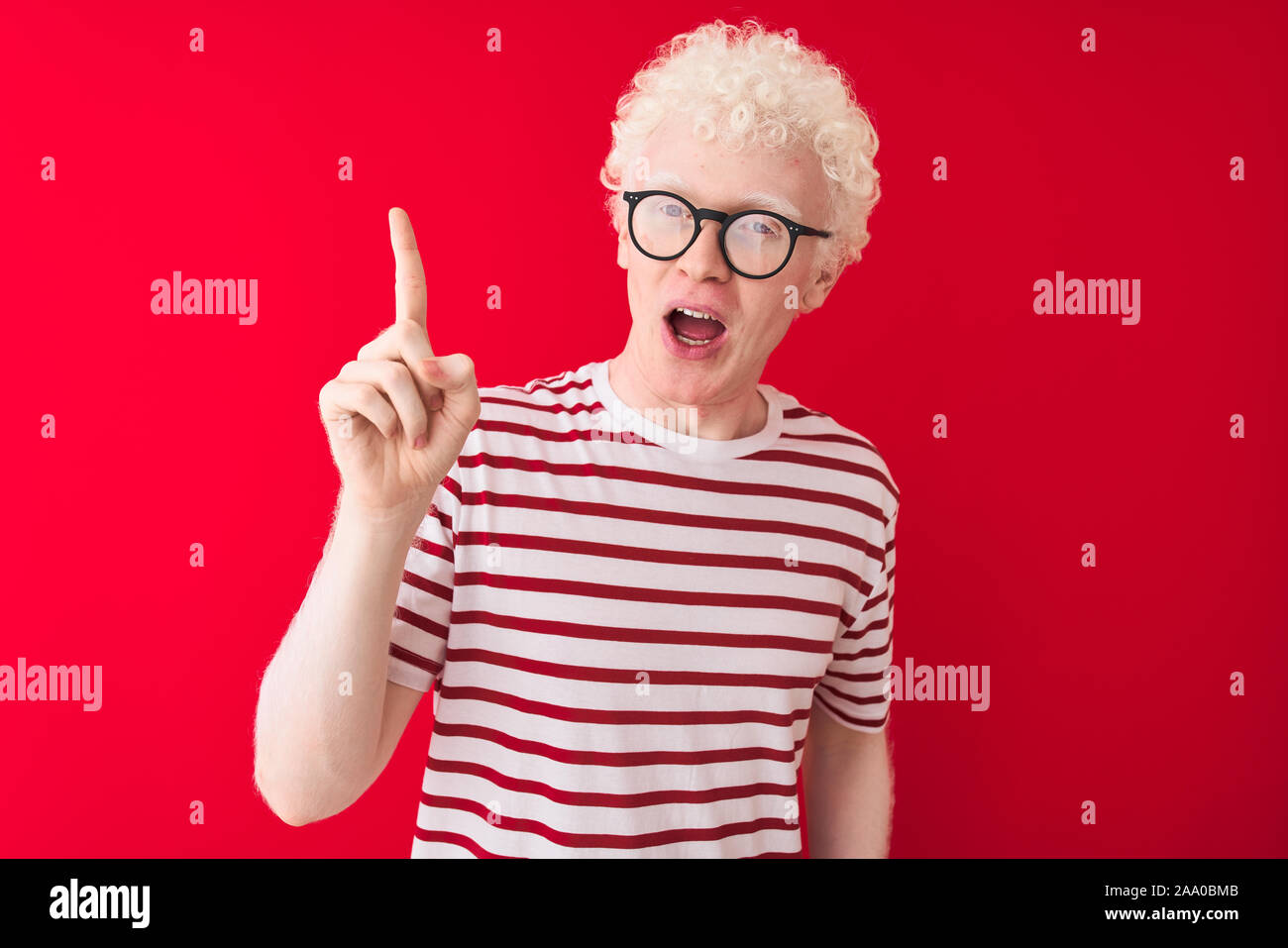 Young albino blond man wearing striped t-shirt and glasses over ...