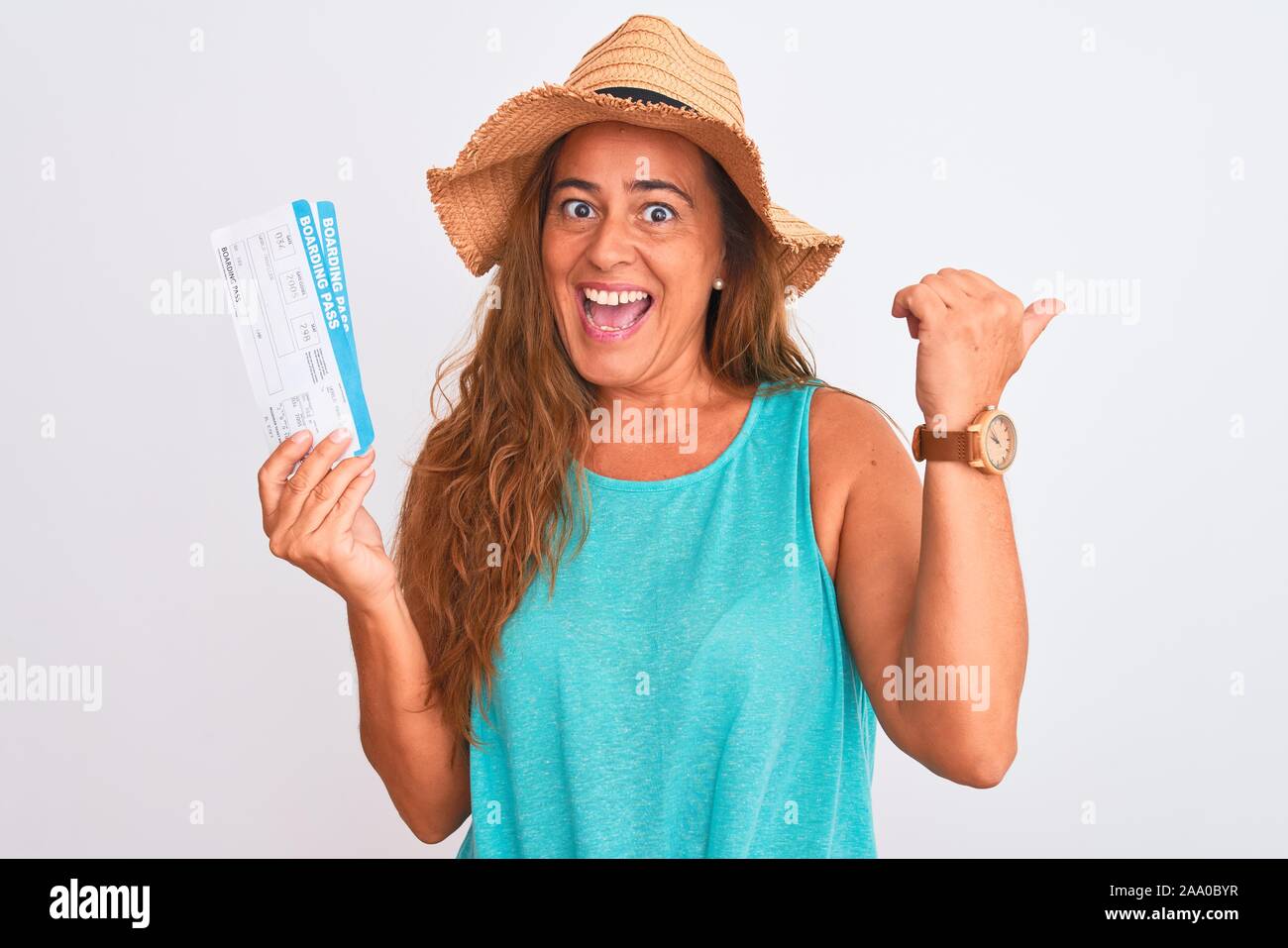 Middle age mature tourist woman holding boarding pass over isolated ...