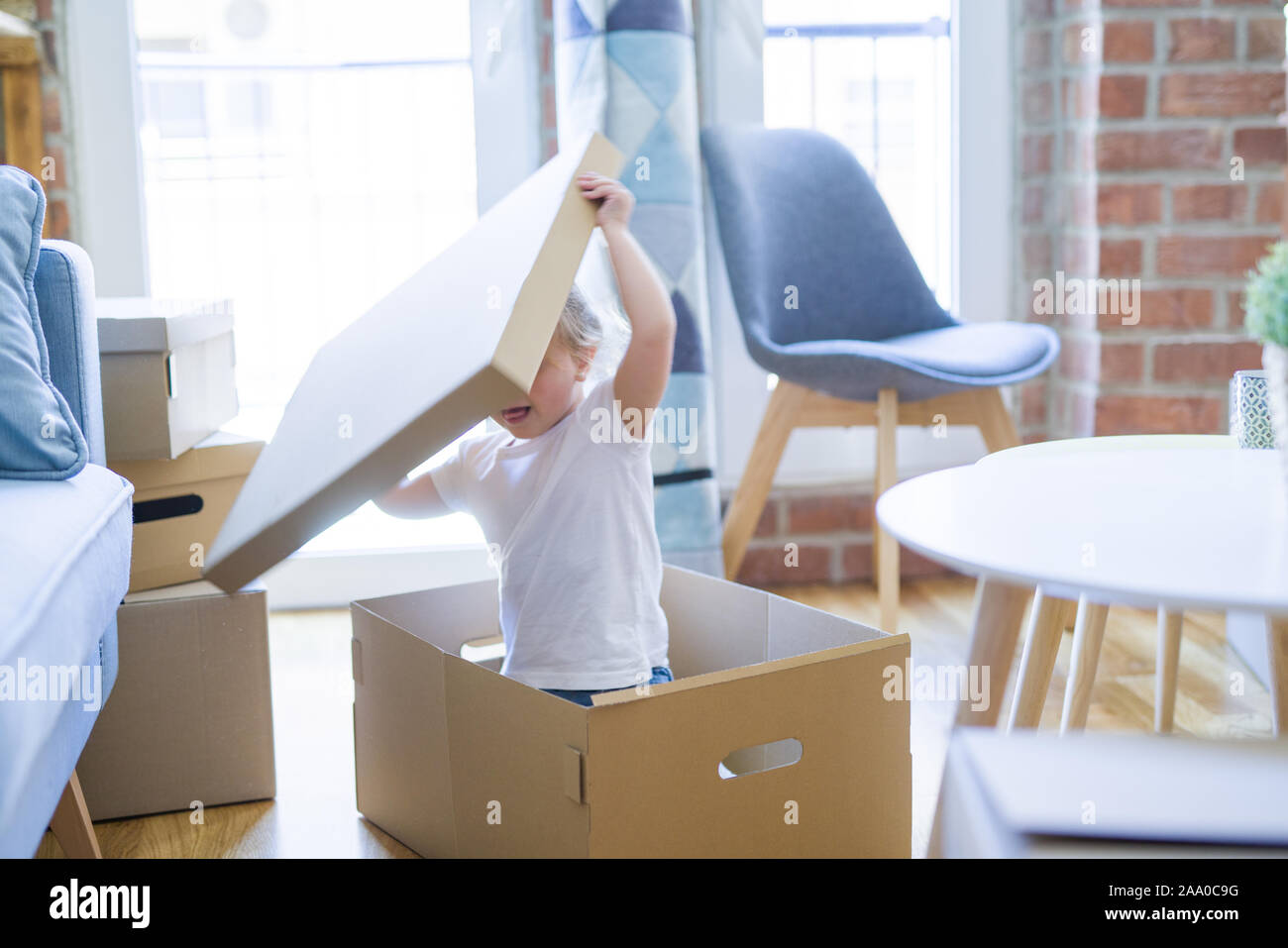 Beautiful toddler child girl playing with boxes at new home Stock Photo ...