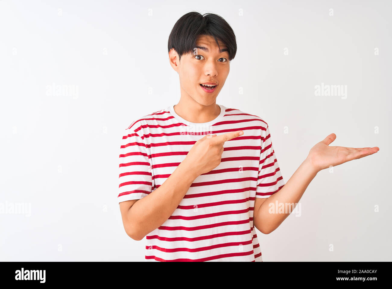 Young chinese man wearing casual striped t-shirt standing over isolated ...