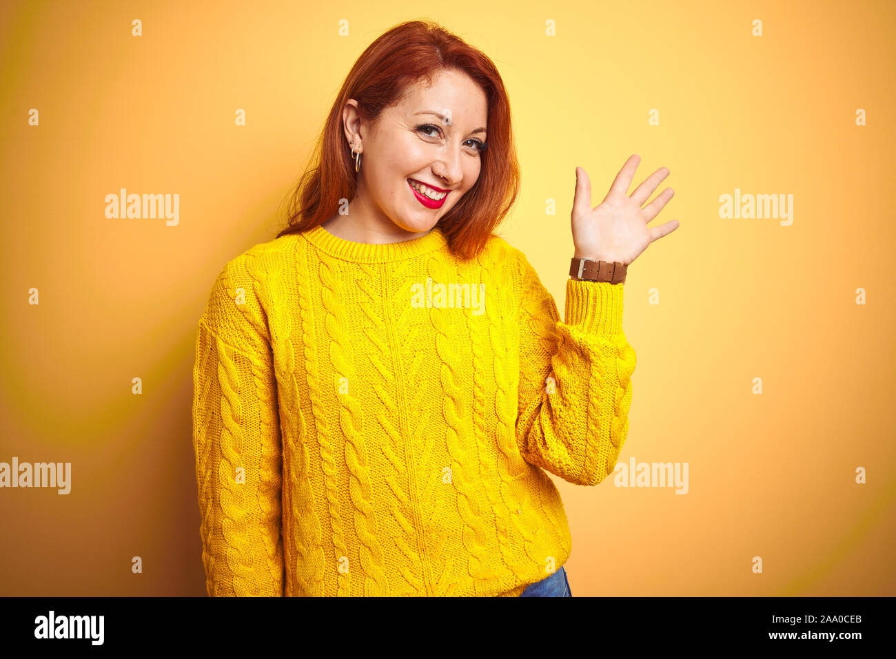 Beautiful redhead woman wearing winter sweater standing over isolated ...