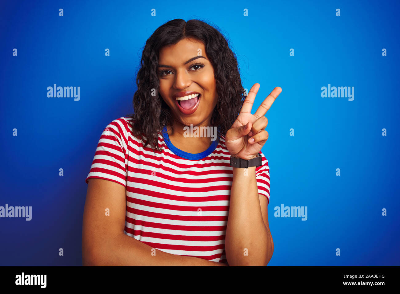 Transsexual transgender woman wearing stiped t-shirt over isolated blue ...