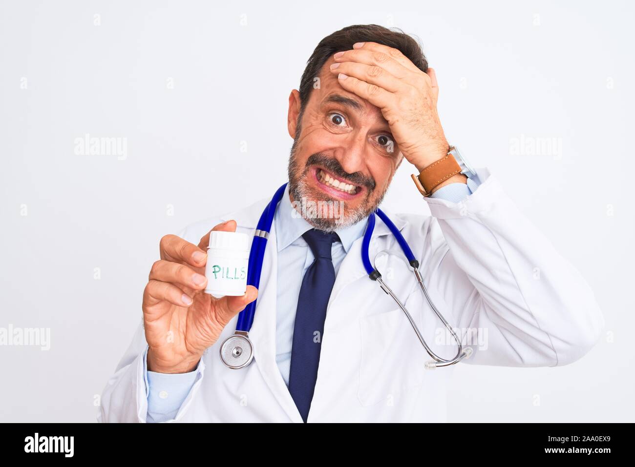 Middle age doctor man holding pills standing over isolated white ...