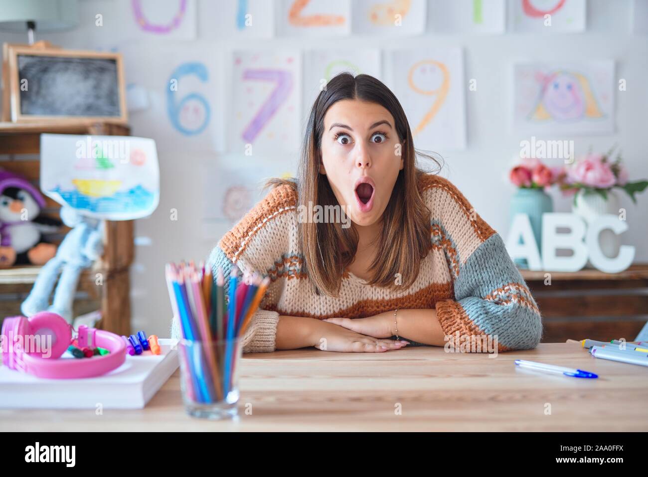 Young beautiful teacher woman wearing sweater and glasses sitting on ...